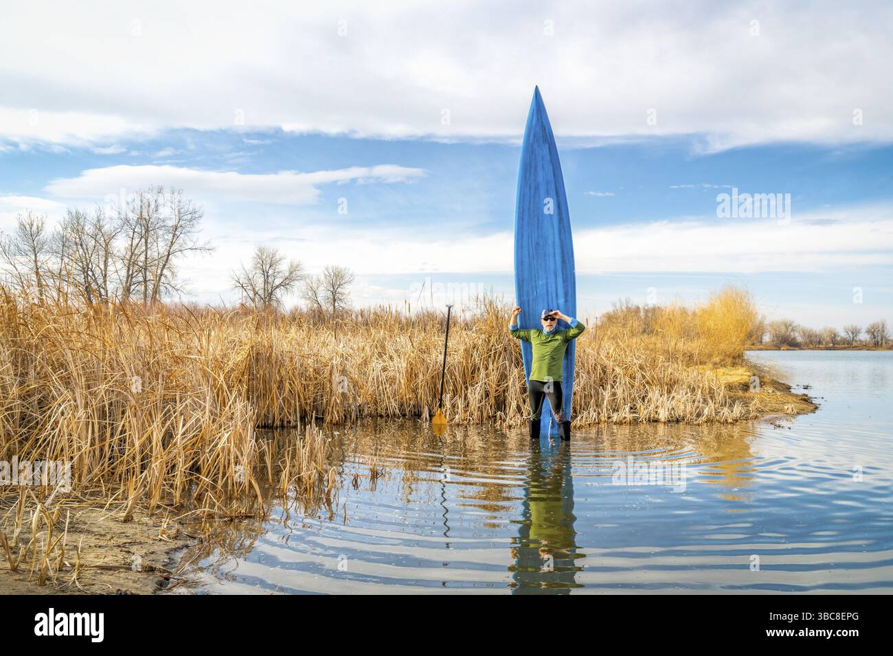 Early spring stand up paddling, senior male with his paddleboard on ...