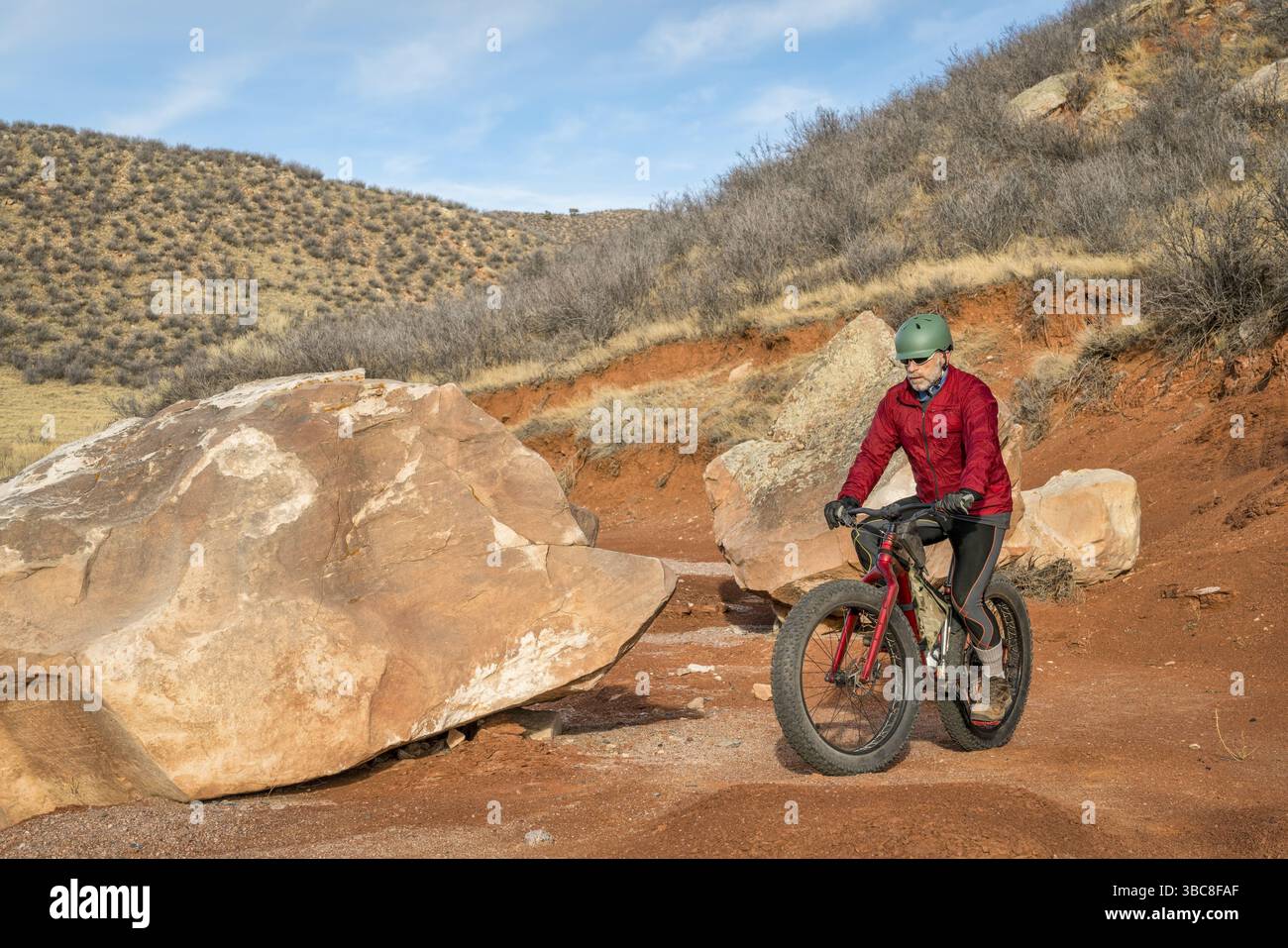 A senior male riding a fat bike on mountain desert trail in Red ...
