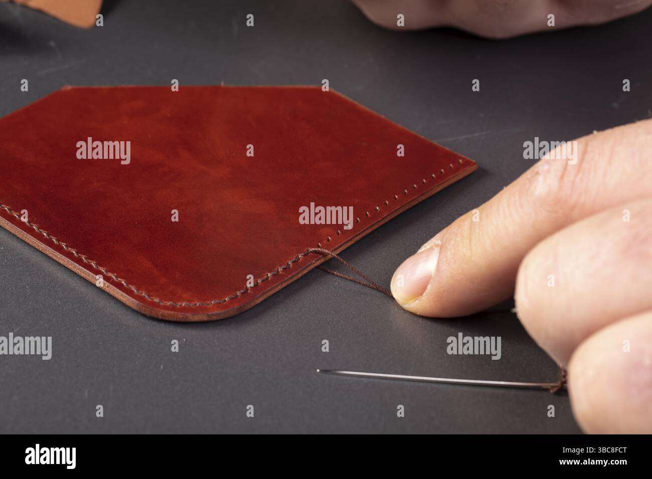 The process of making leather goods. The hands of the master craftsman ...