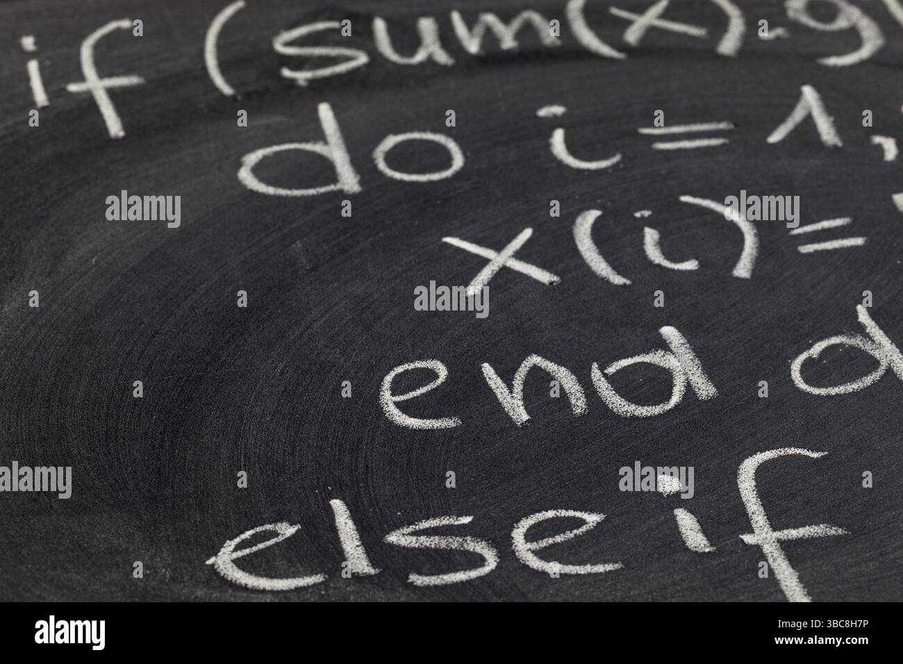 A detail of computer code in Fortran explained with white chalk on ...