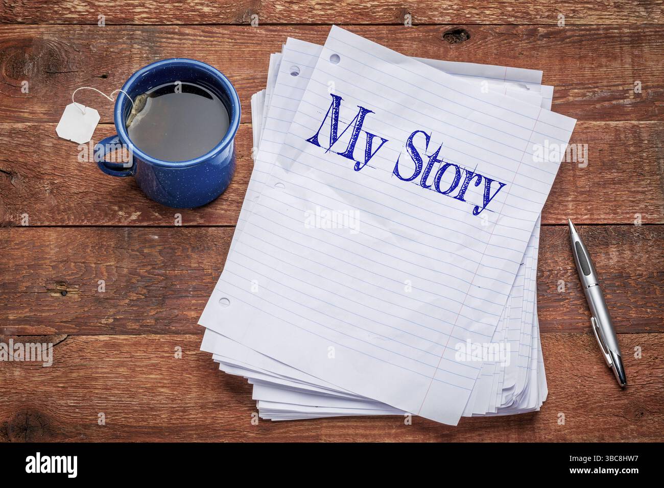 My story handwriting - stack of paper sheets on a rustic wood table ...