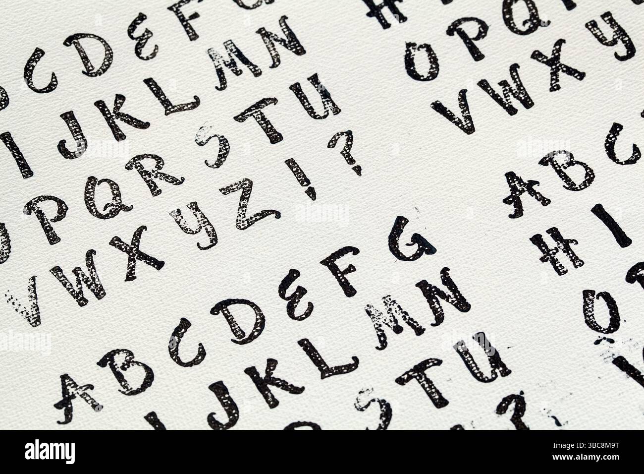 Rubber stamp alphabet abstract printed in black ink on white artist ...