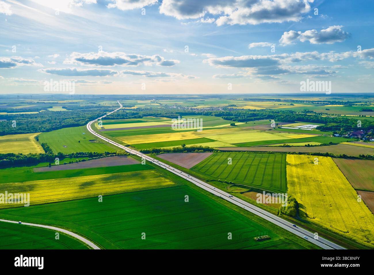 Aerial view of highway cutting through agricultural fields with ...
