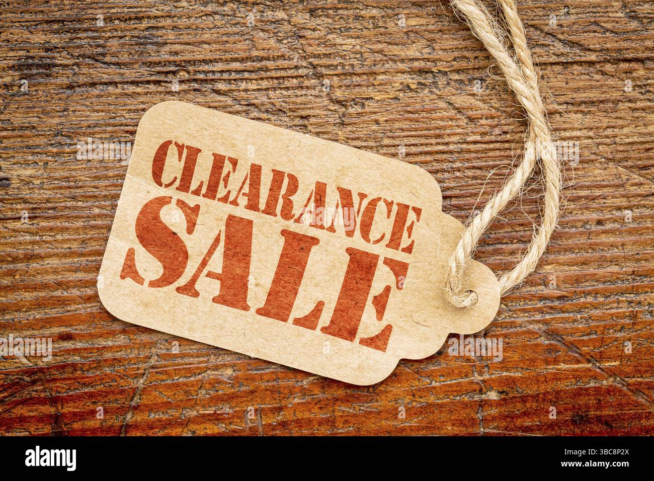 Clearance sale sign a paper price tag against rustic red painted barn ...