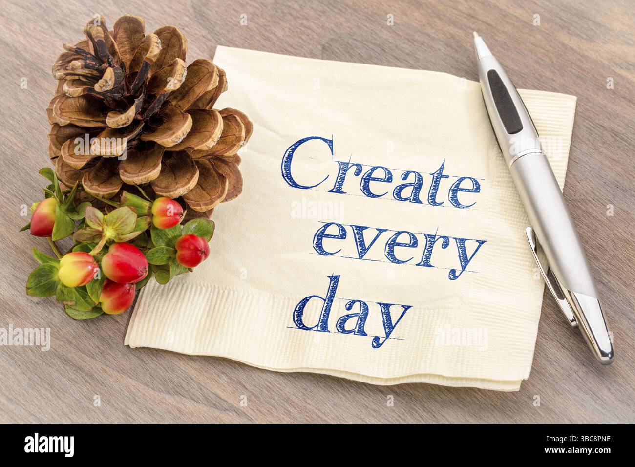 Create every day inpirational advice - handwriting on a napkin with a pine cone Stock Photo - Alamy