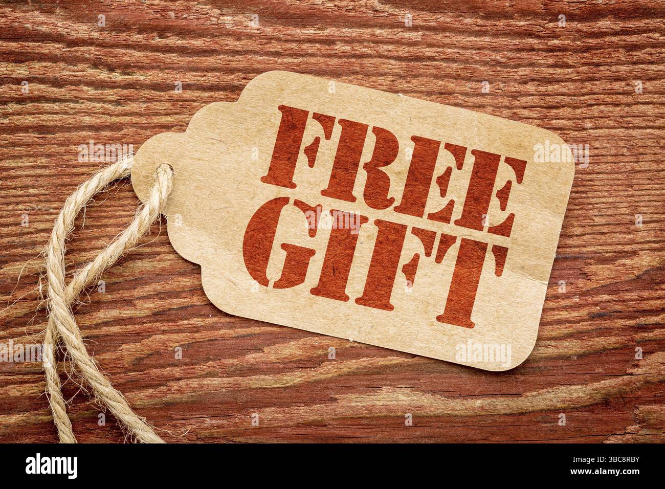 Free gift sign - red stencil text a paper price tag against rustic wood ...