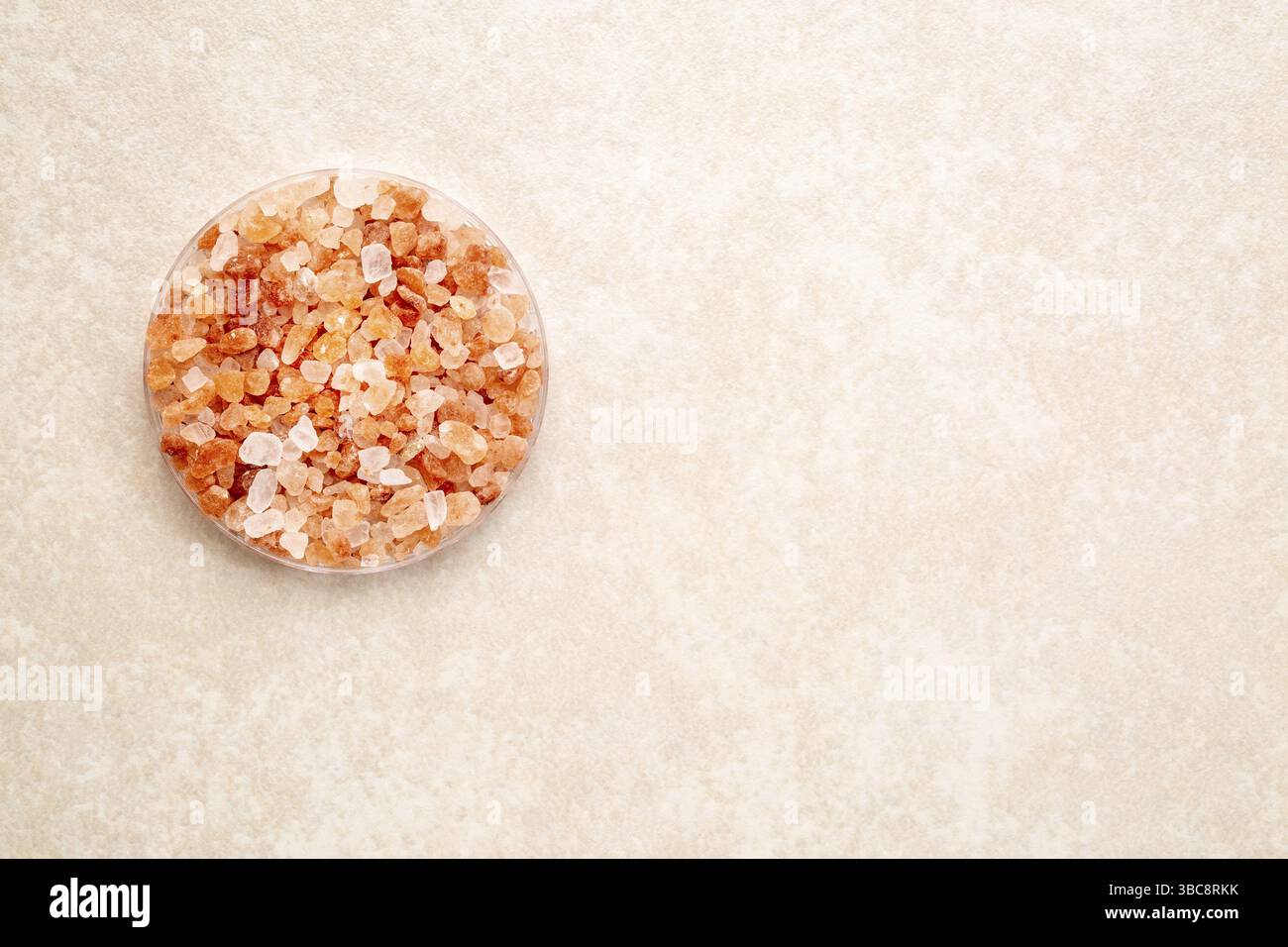 Coarse crystals of pink Himalayan salt in a round bowl against ceramic ...