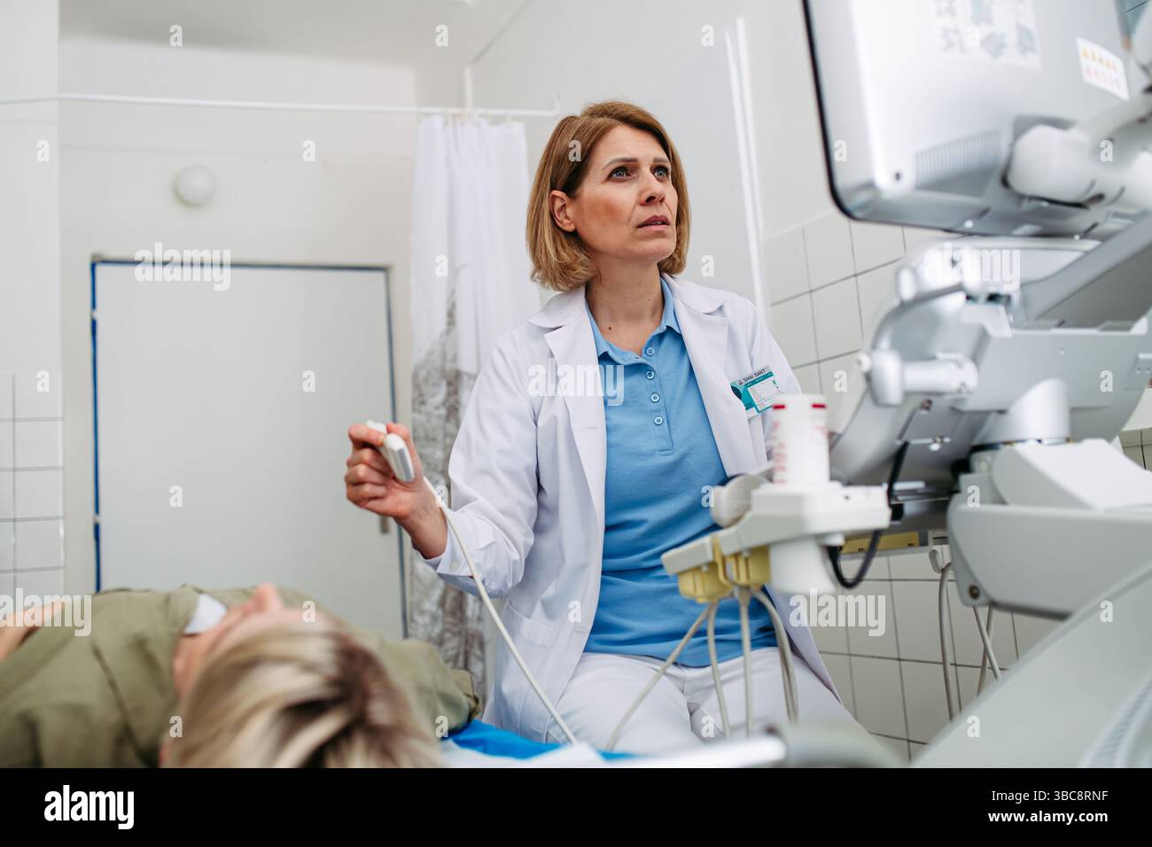Doctor performing diagnostic ultrasound during preventive care Stock ...