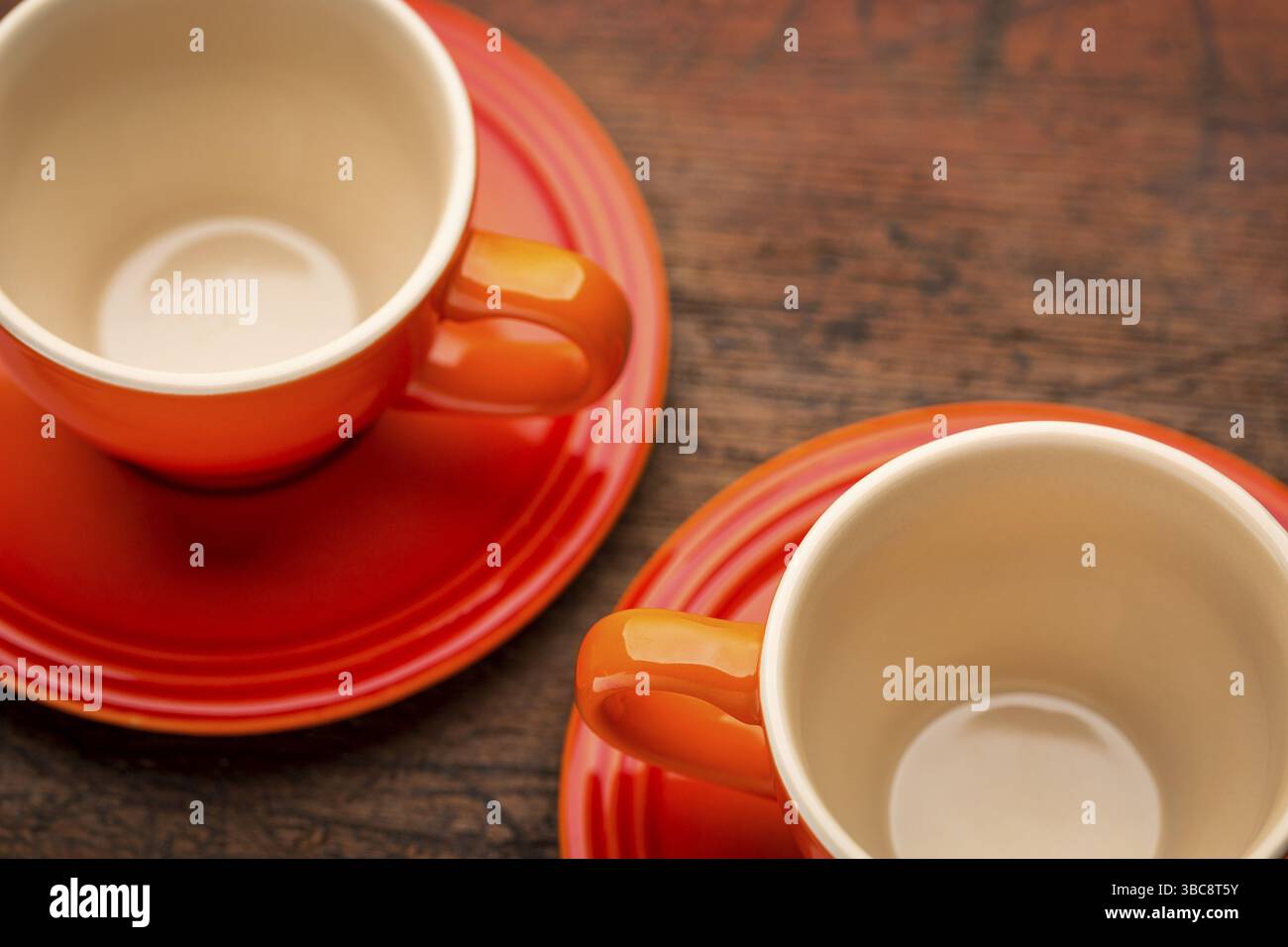 Two empty stoneware coffee cups against grunge wood table, shallow ...