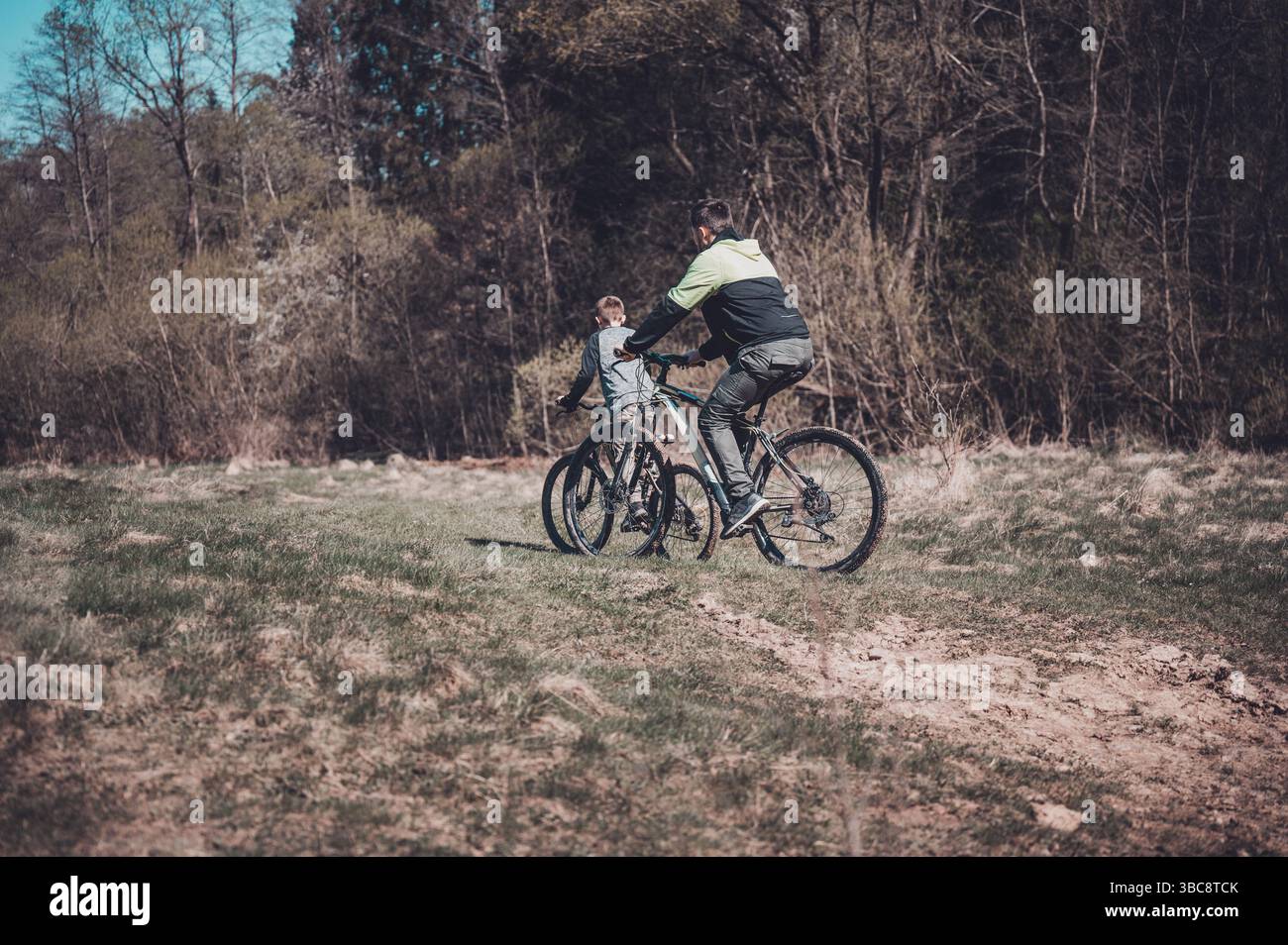 Father and son enjoy a bike ride through a tranquil forest path Stock ...