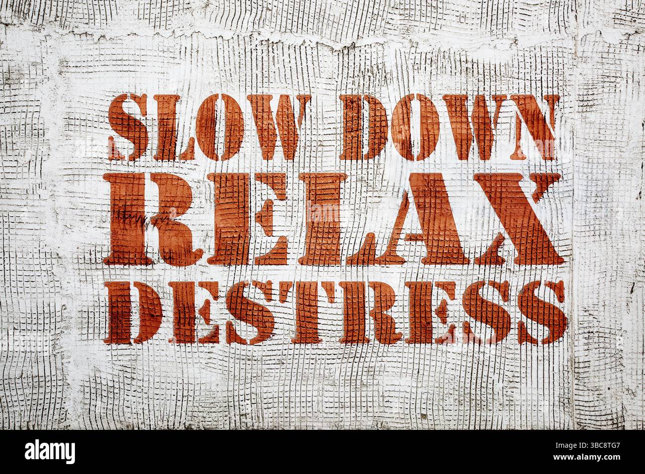 Slow down, relax and destress - graffiti sign on a stucco wall Stock ...