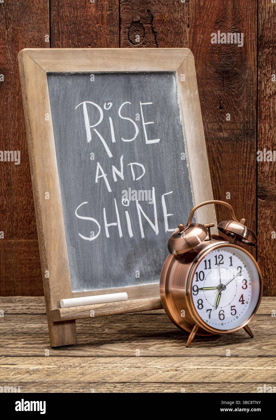 Rise and shine sign - white chalk handwriting on a blackboard with an ...