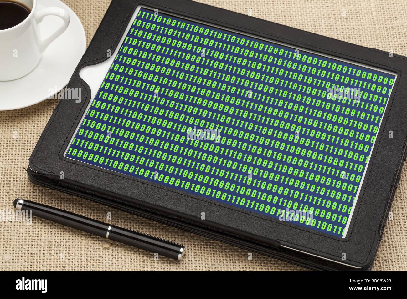 Zero one binary data on a screen of a digital tablet with a cup of ...