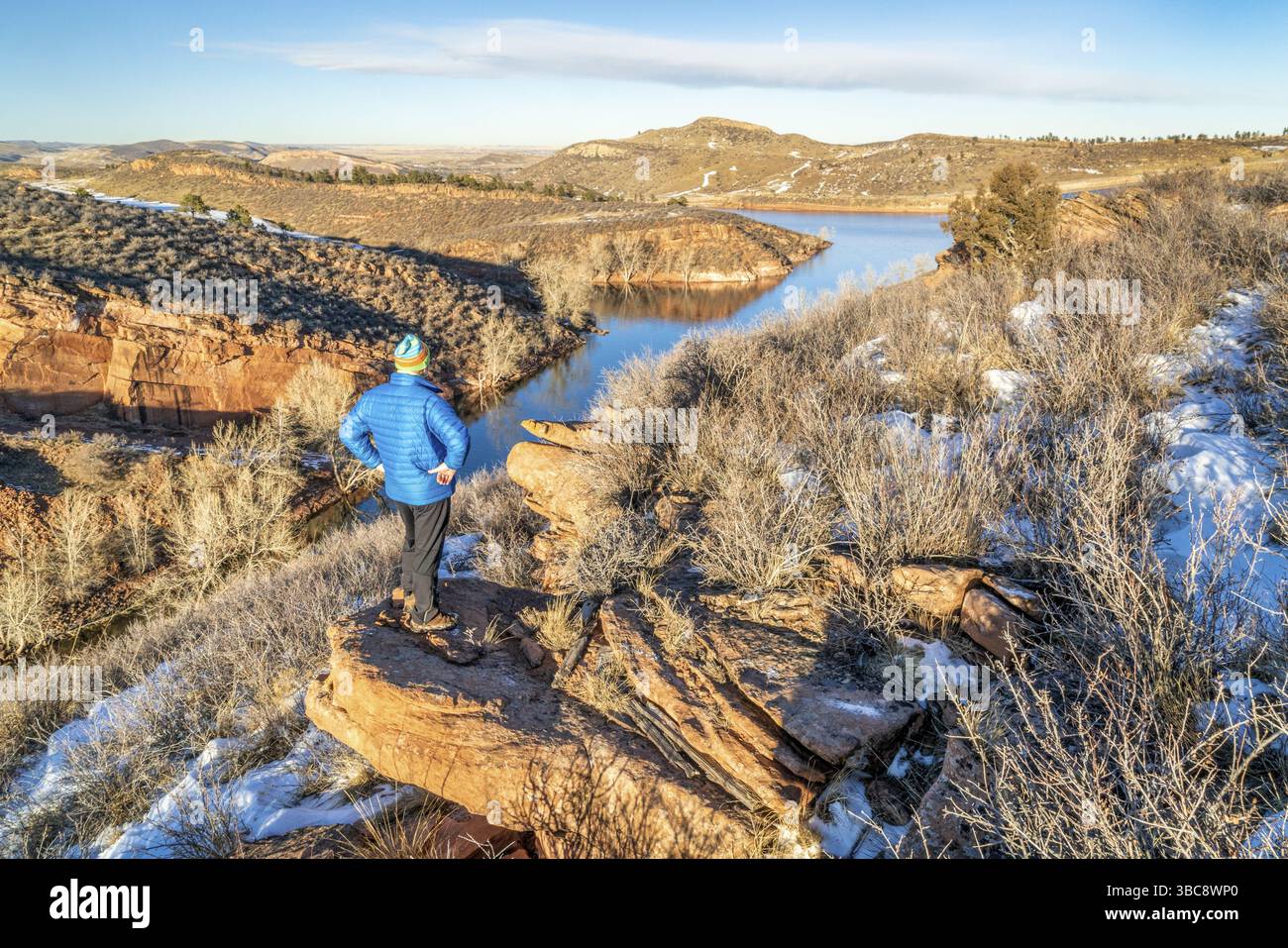 Male hiker on a sandstone cliff looking mountain lake below - Lory ...
