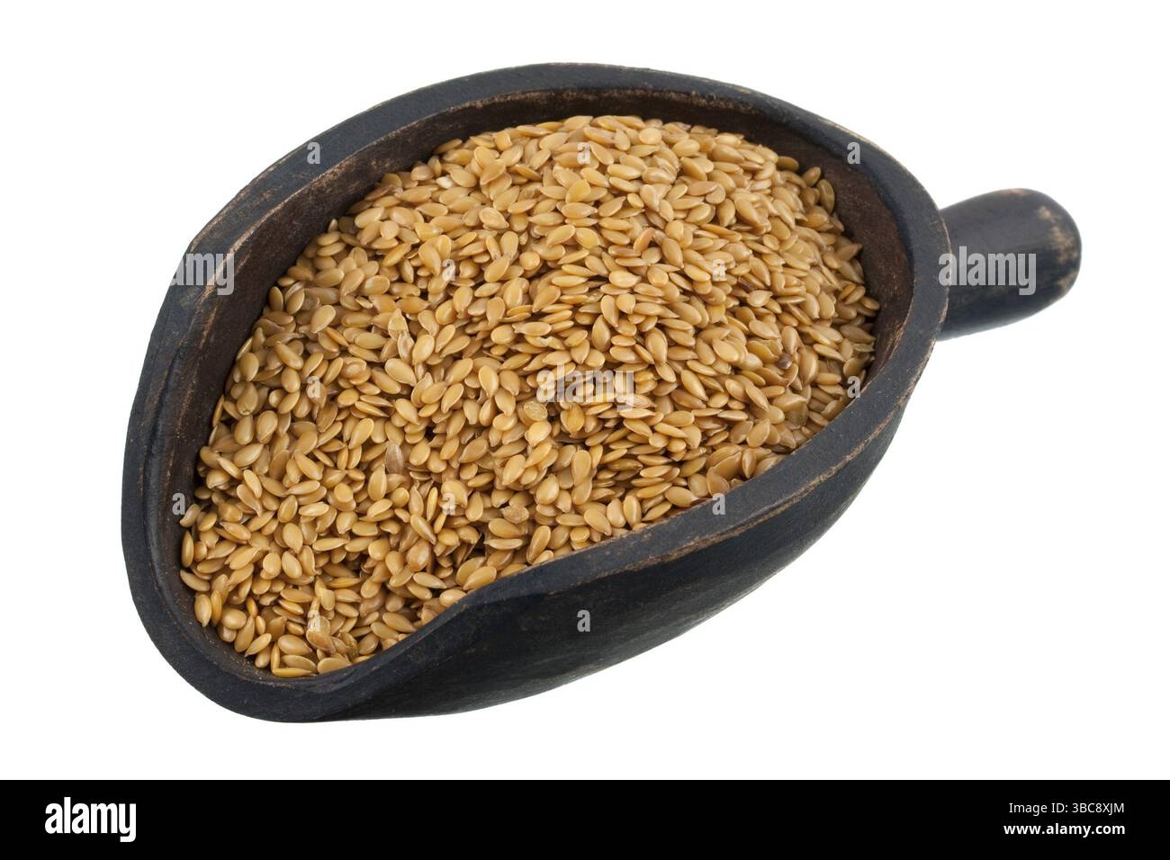 Golden flax seeds on a rustic, wooden, dark painted scoop, isolated on ...