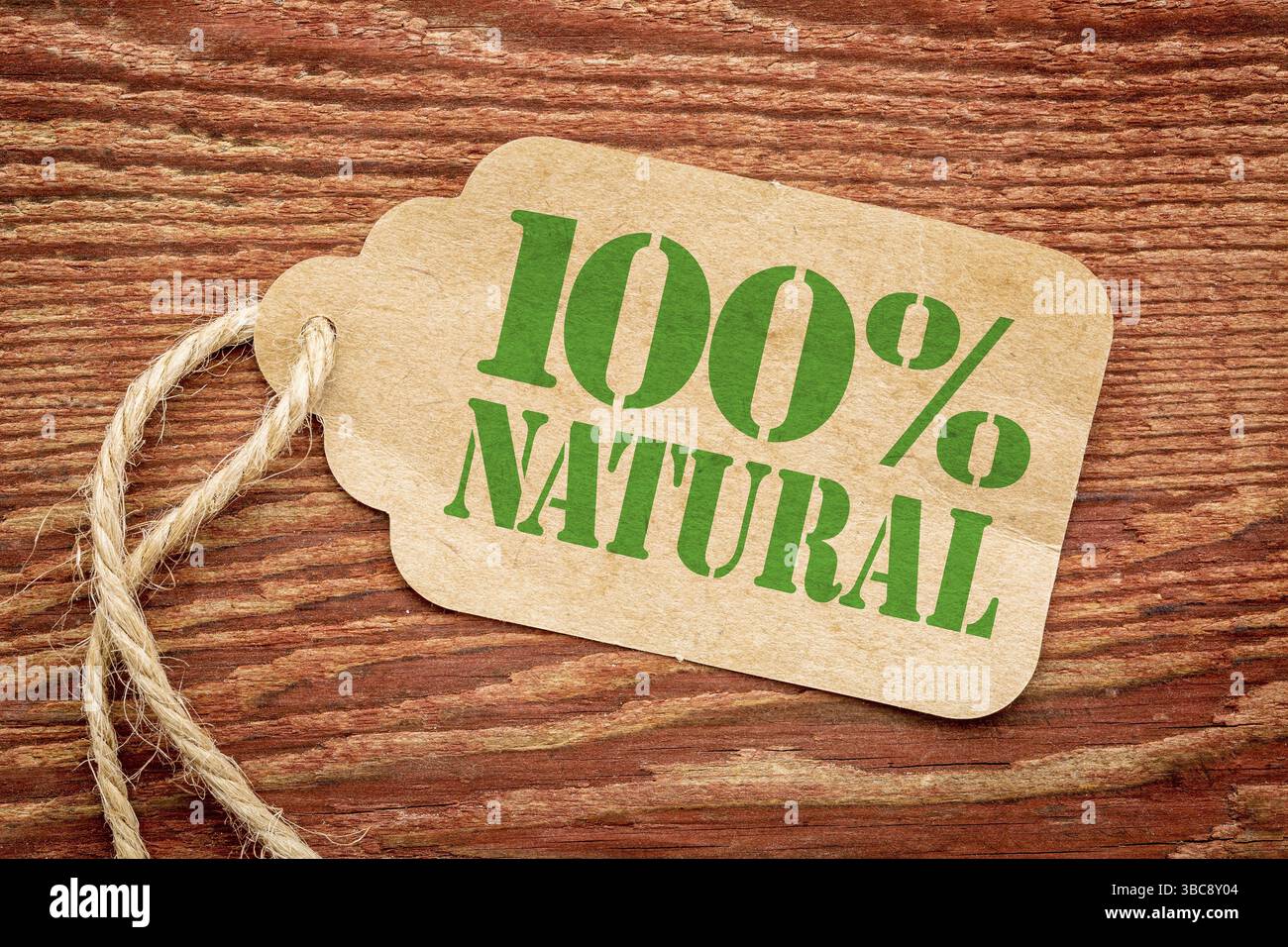 One hundred percent natural sign - a paper price tag against rustic red ...