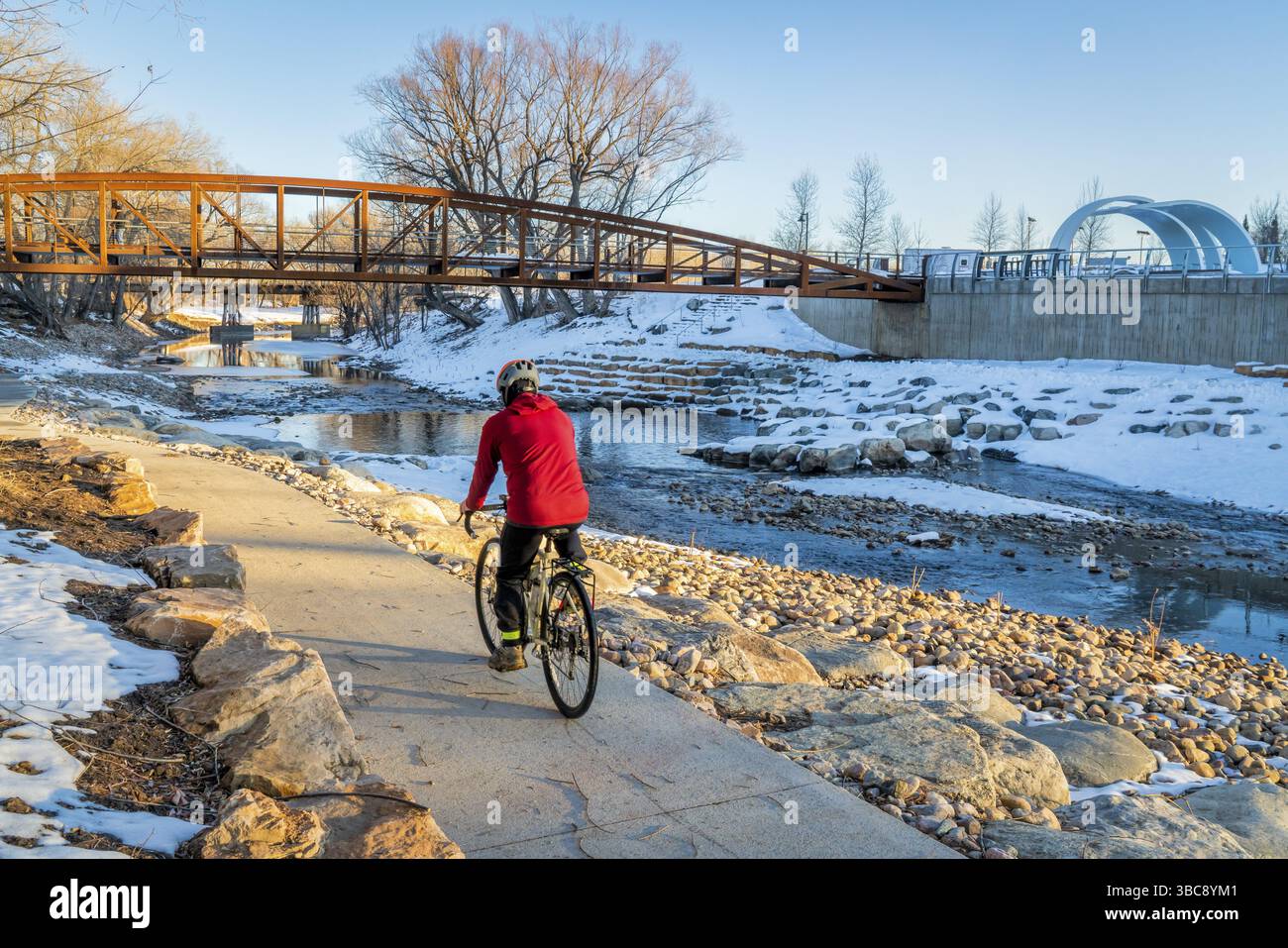 Male cyclist is riding a bike in winter sunset scenery - Poudre River ...