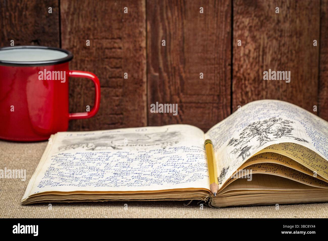 Vintage expedition journal with a metal cup of hot tea - handwriting ...