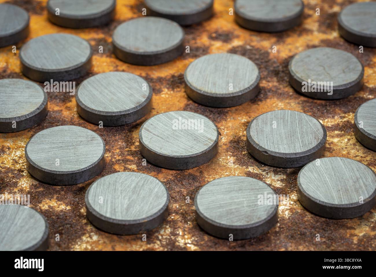Set of small round ceramic ferrite magnets - top view against rusty ...