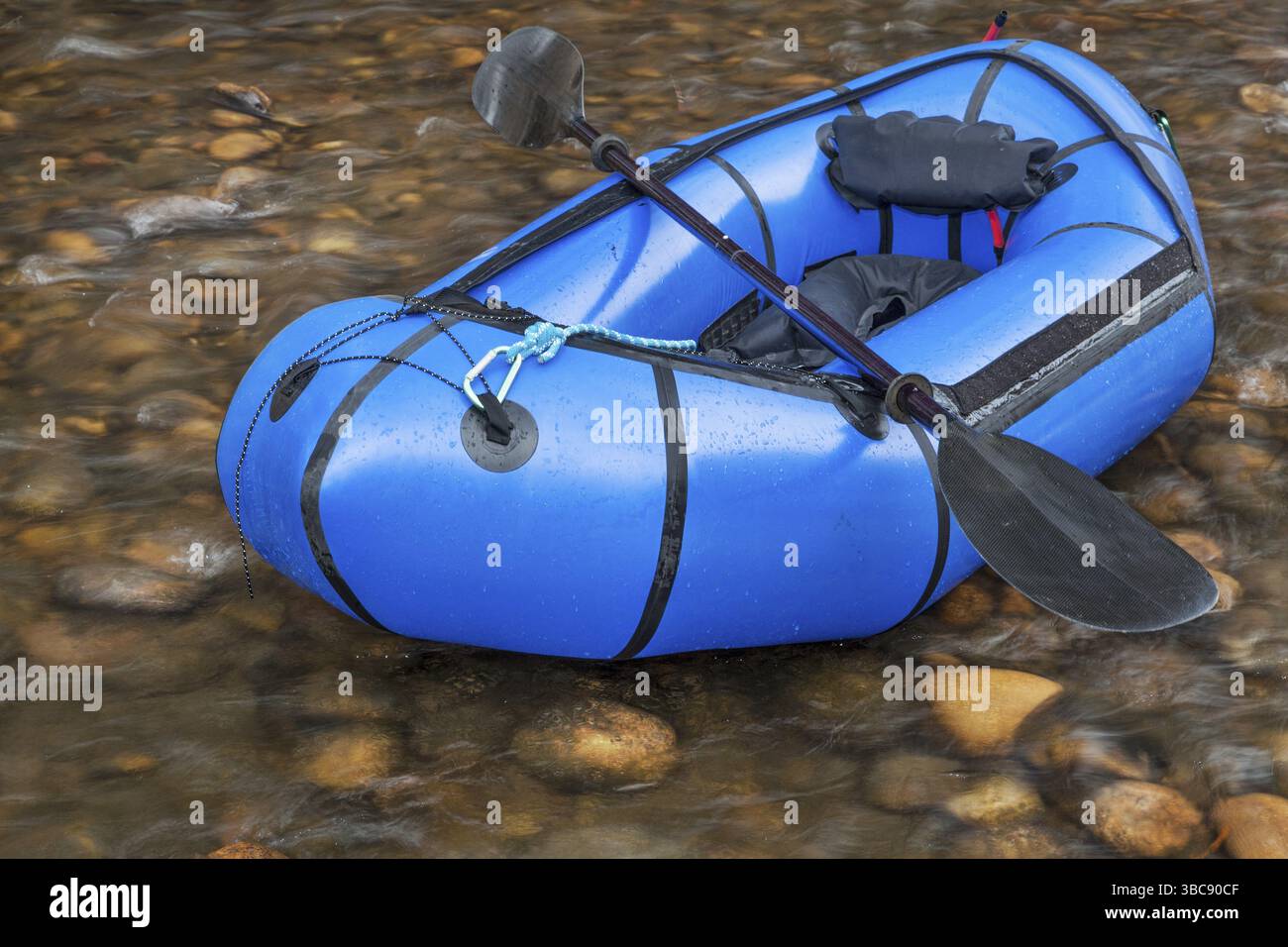 A blue pacraft (one-person light raft used for expedition or adventure ...