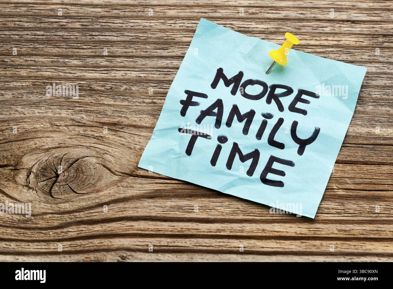 More family time reminder note against grained weathered wood Stock ...