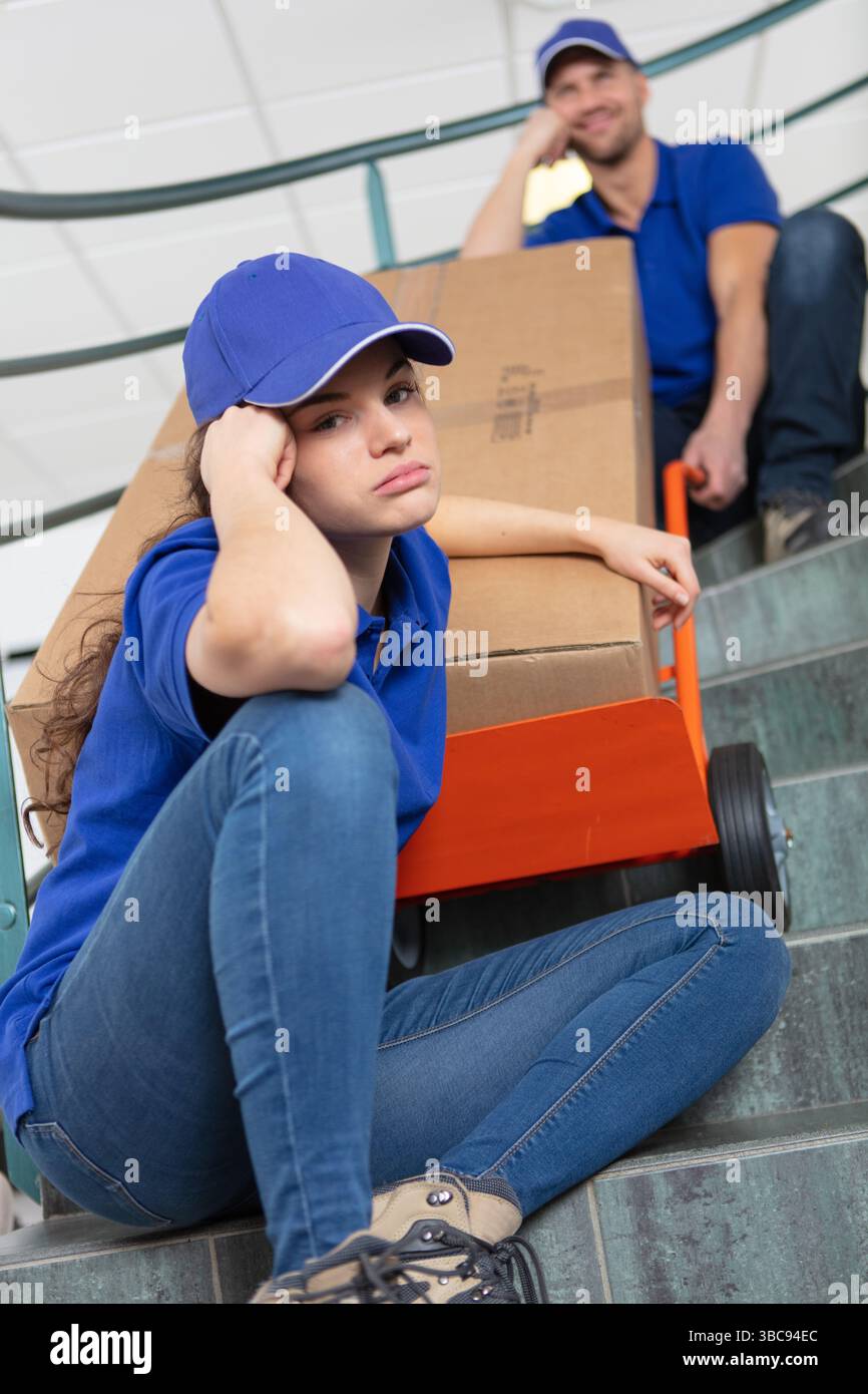 lady struggling to push trolley up stairs loaded with box Stock Photo ...