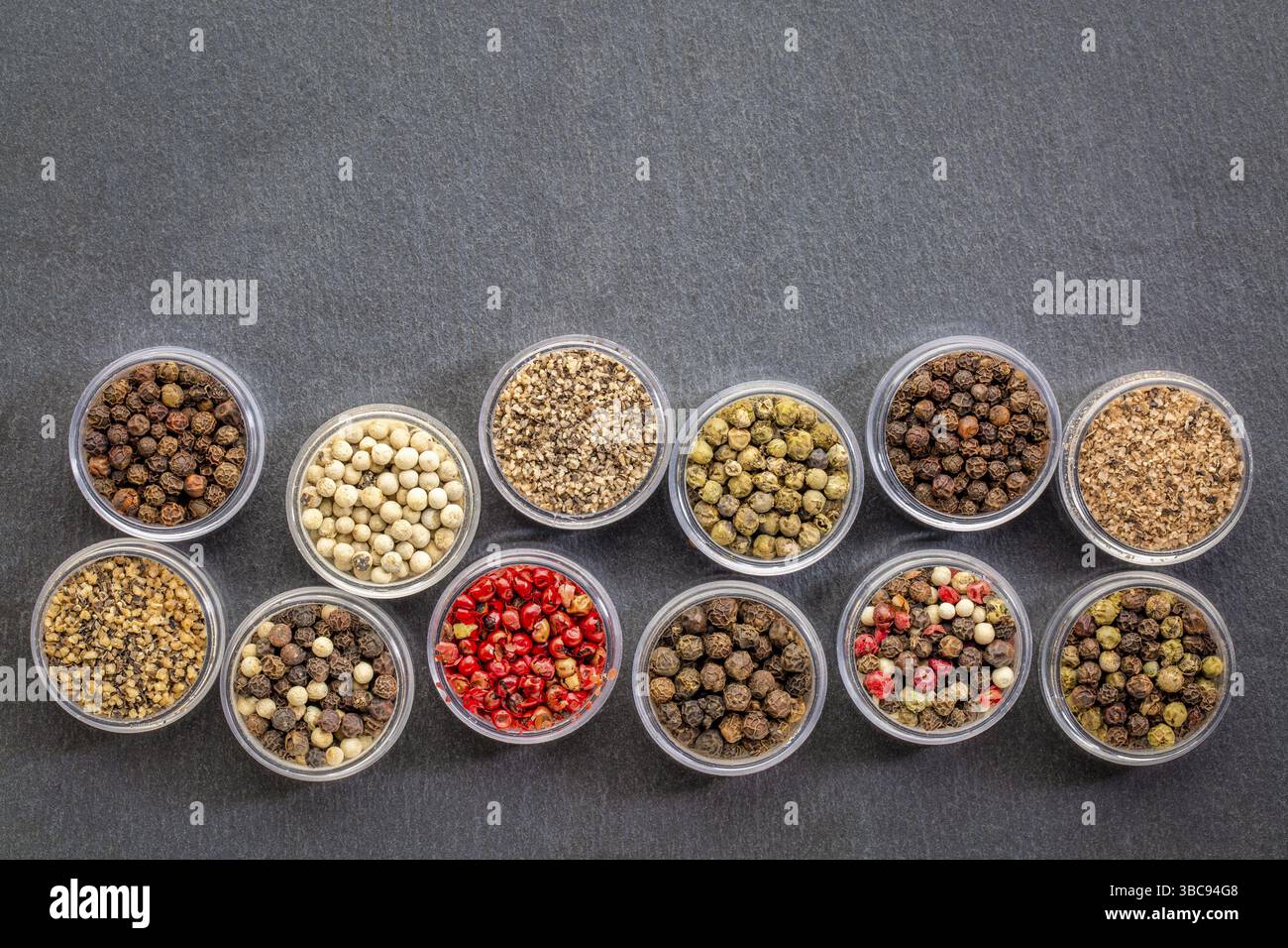 Set of colorful peppercorn samples of the world on a slate stone with a ...