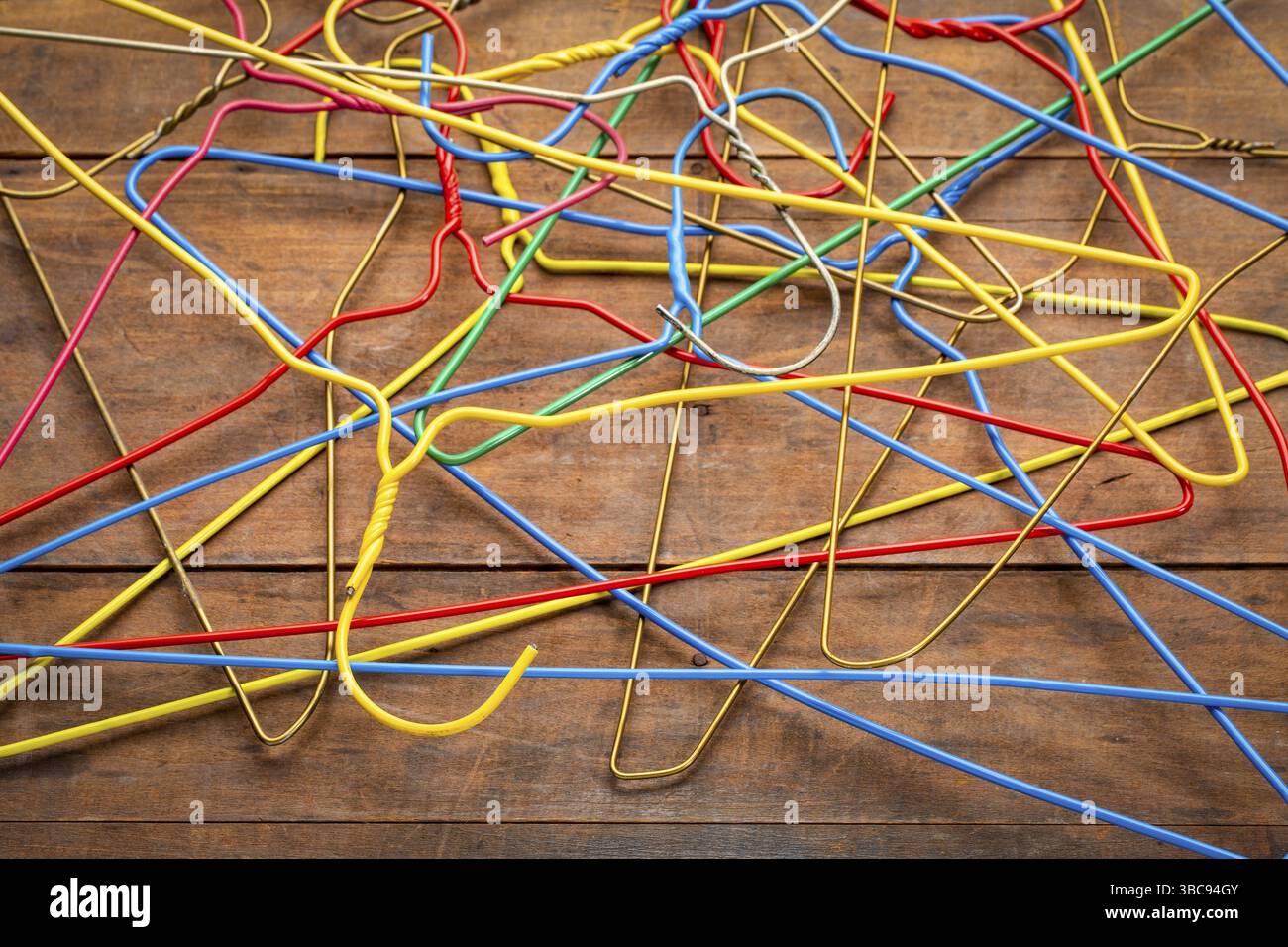 A pile of wire hangers on a rustic wood, mess or decltuering concept ...