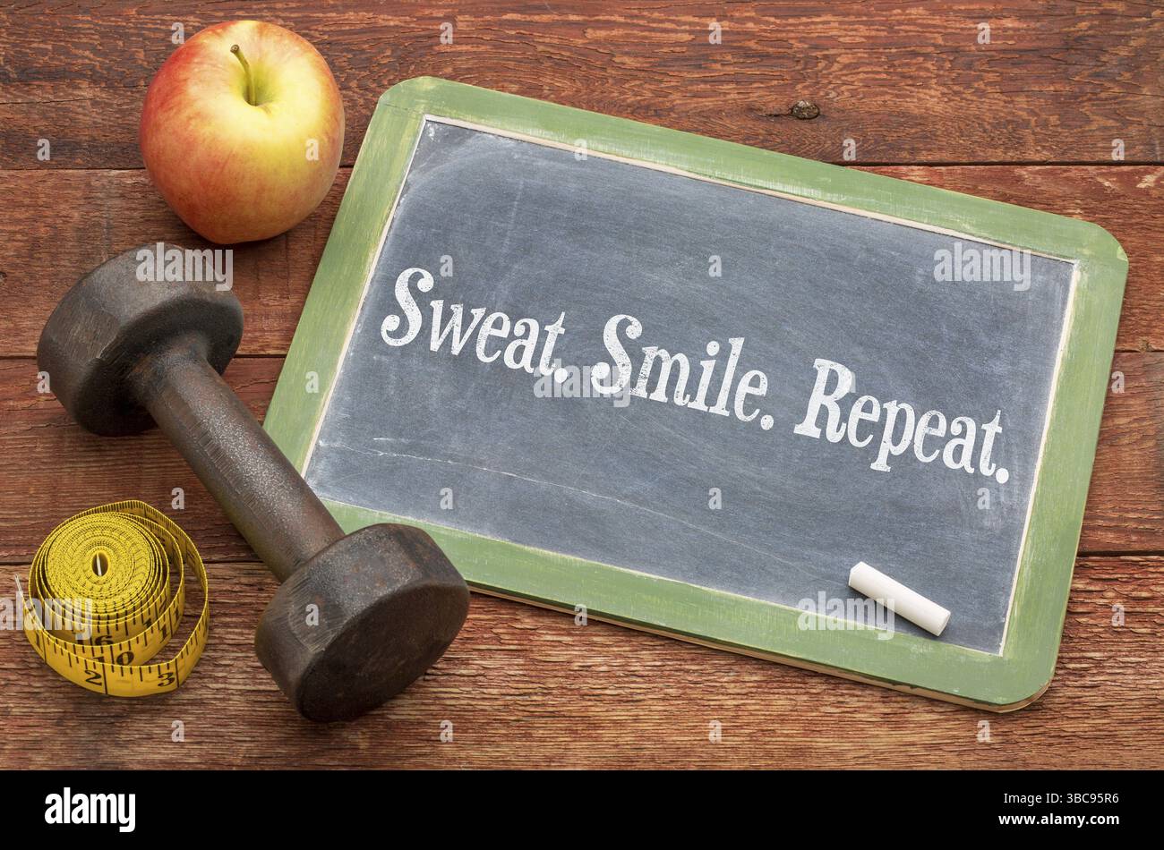 Sweat, smile, repeat fitness concept - slate blackboard sign against ...