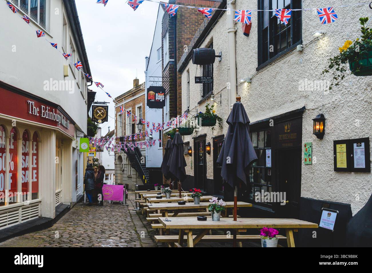 Charming cobbled street in Windsor, England, with British flags ...