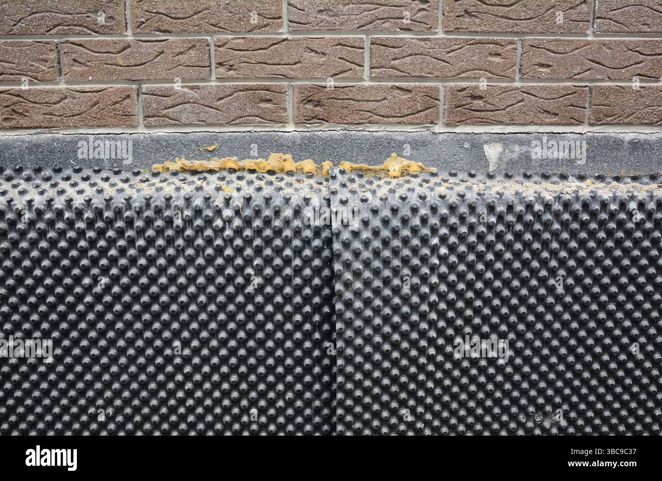 Brick house foundation waterproofing close up Stock Photo - Alamy