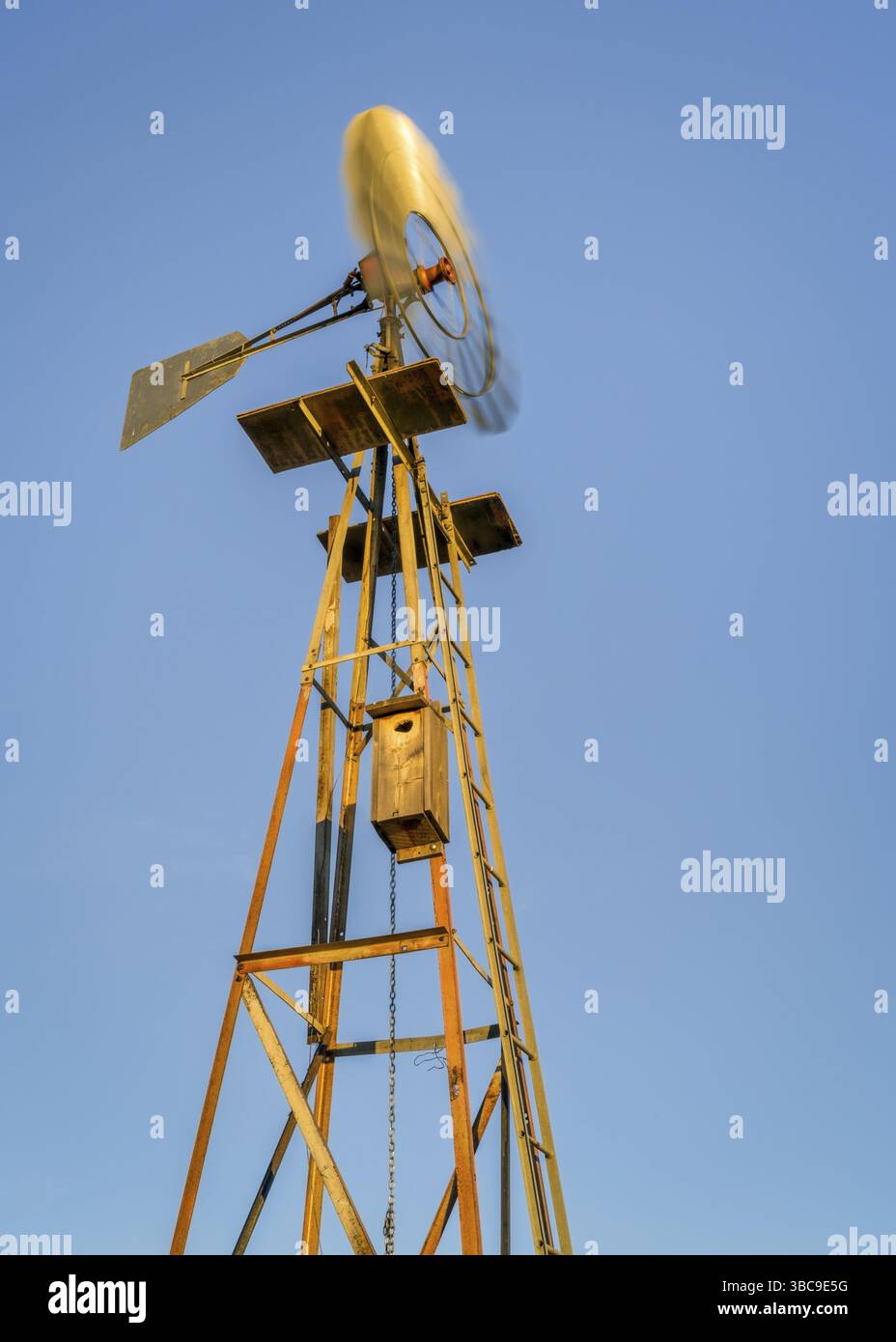Windmill pumping water for cattle at Colorado foothills Stock Photo - Alamy