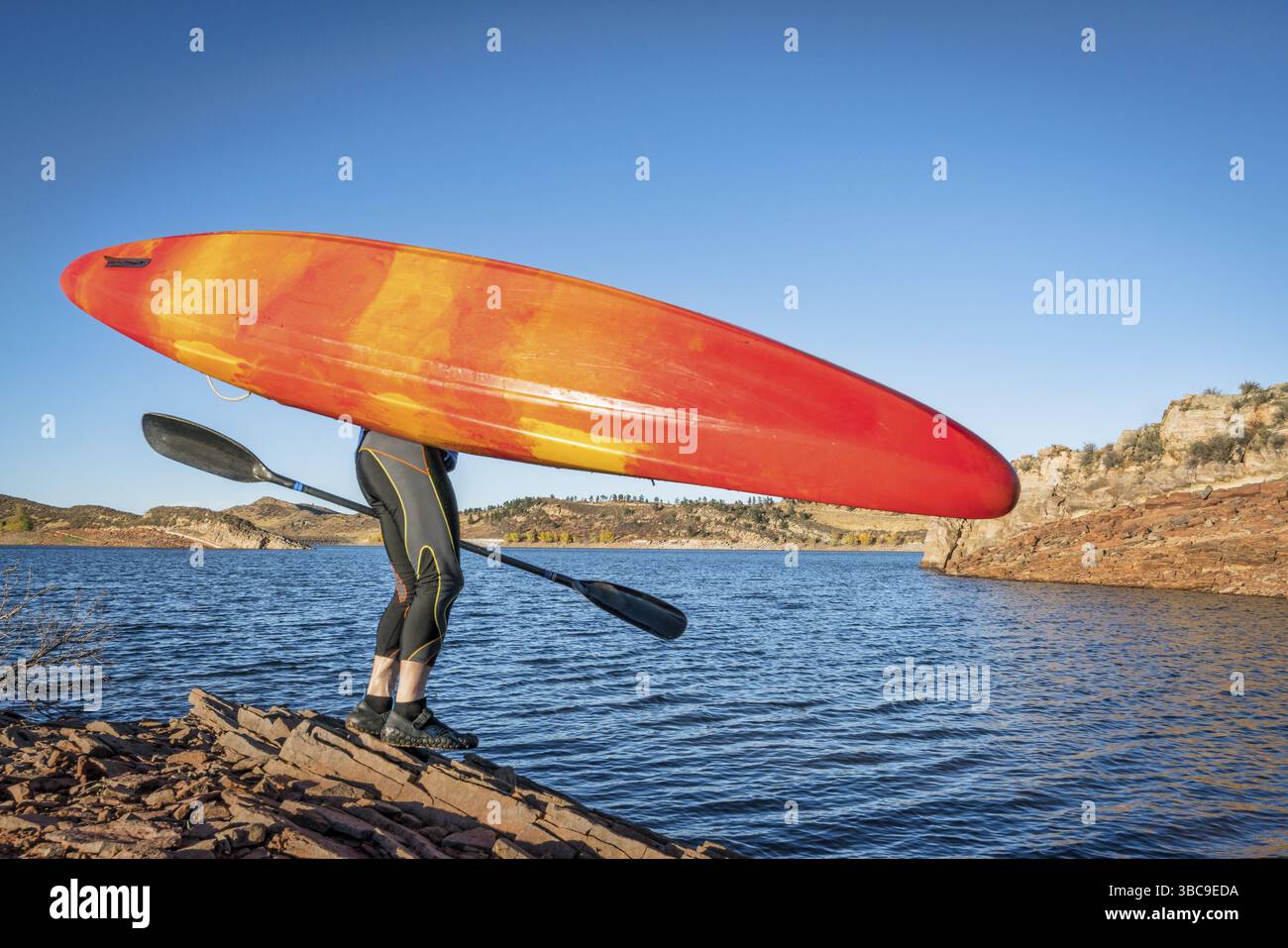 Portaging and launching kayak on lake shore, Horsetooth REservoir ...