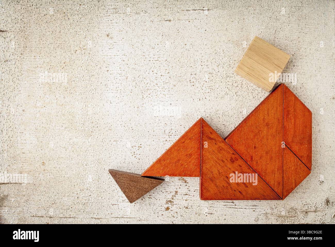 Abstract sitting or relaxing figure built from seven tangram wooden ...