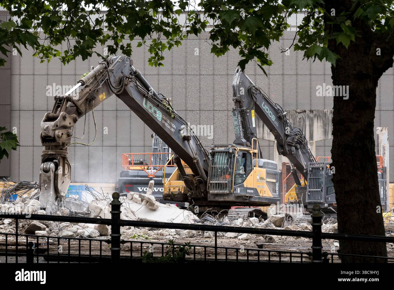 Heavy machinery breaking rubble from demolished pedestrian bridge ...