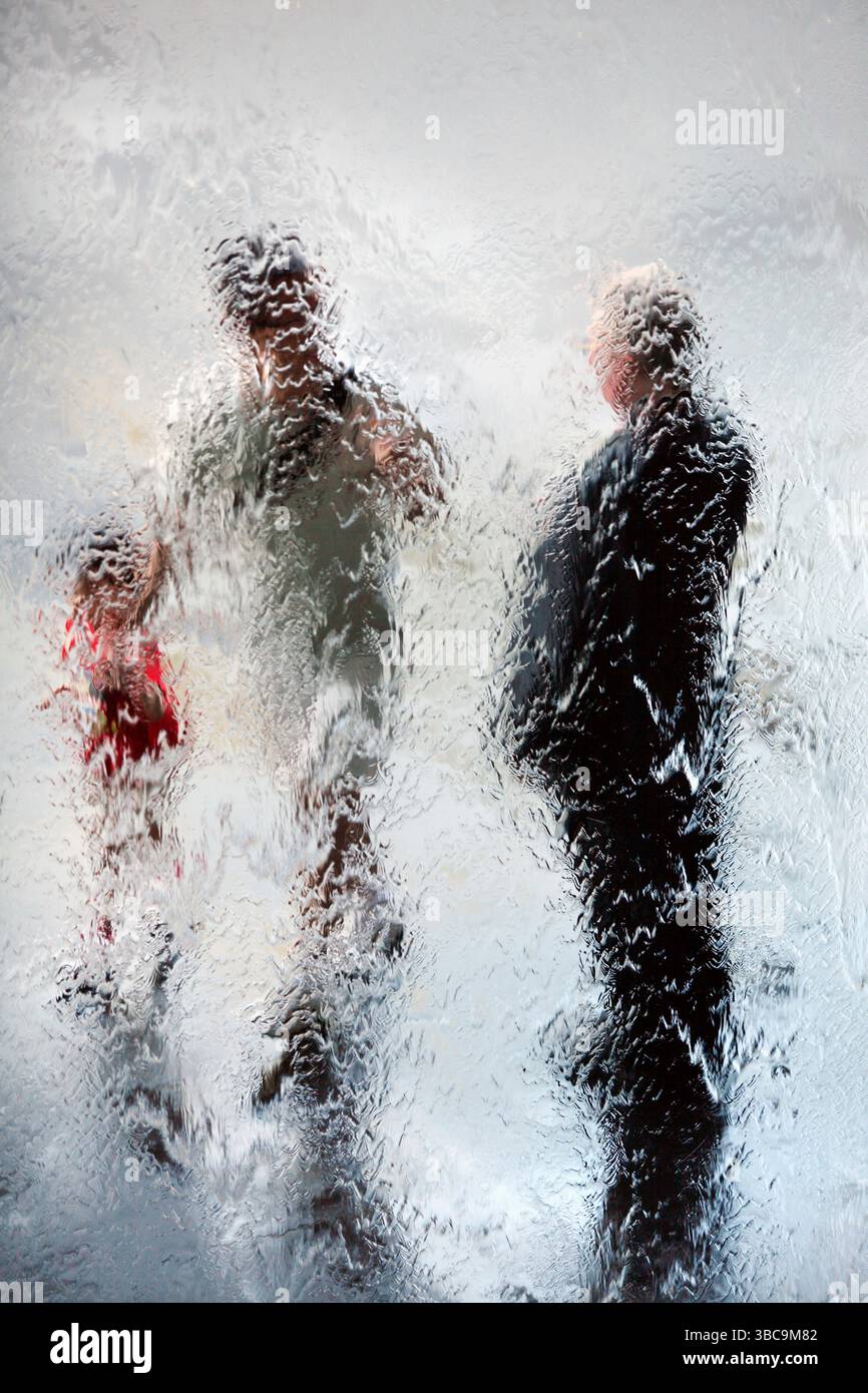 Pedestrians pass in front of the 'water wall' at the front entrance of ...