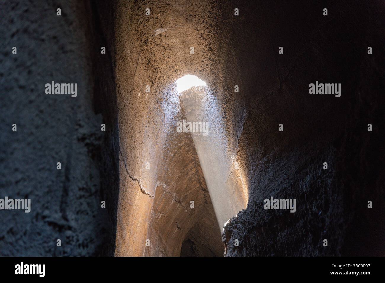Sunbeam entering volcanic cave through narrow ceiling slit Stock Photo ...