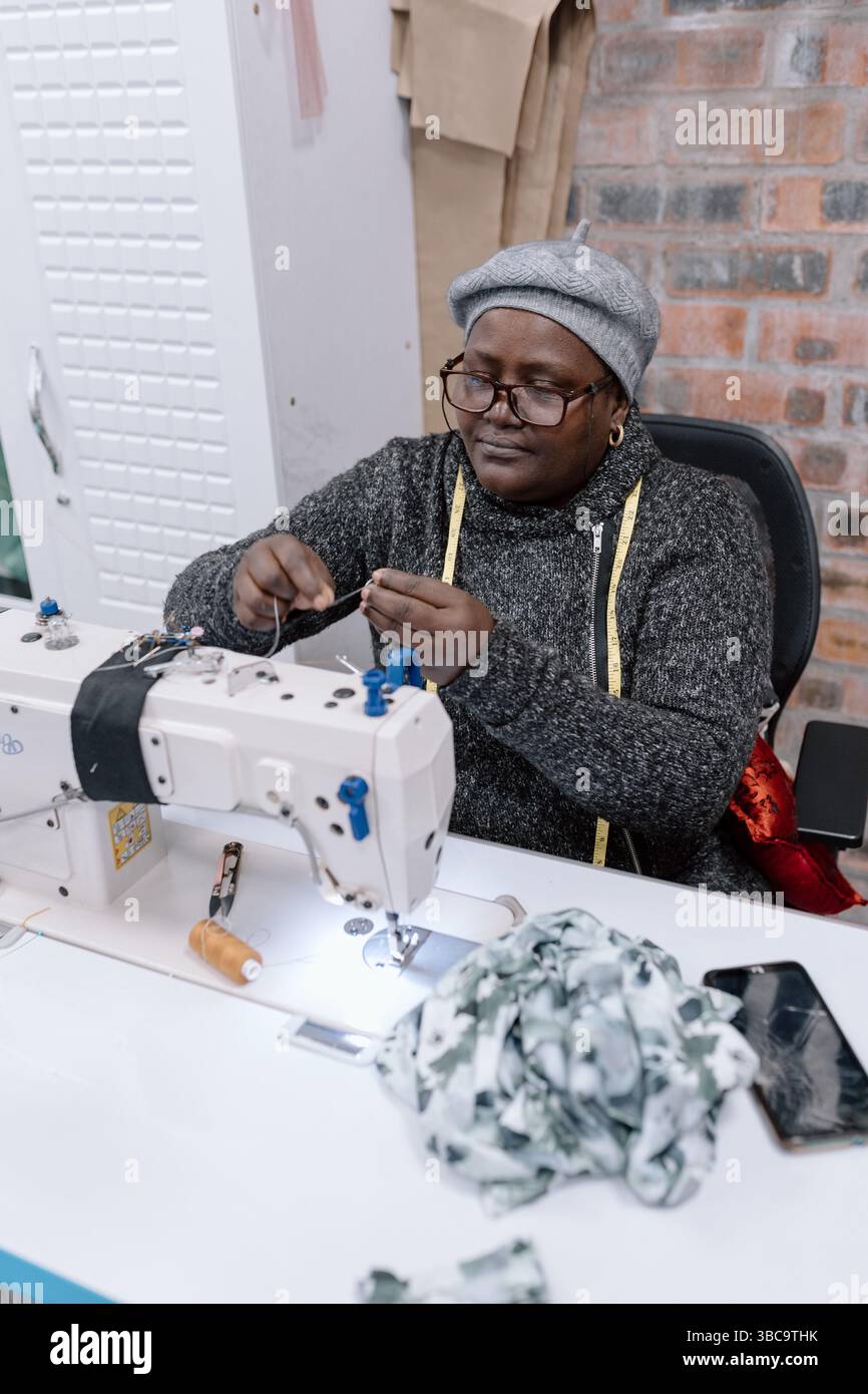 Woman threading a sewing machine Stock Photo - Alamy
