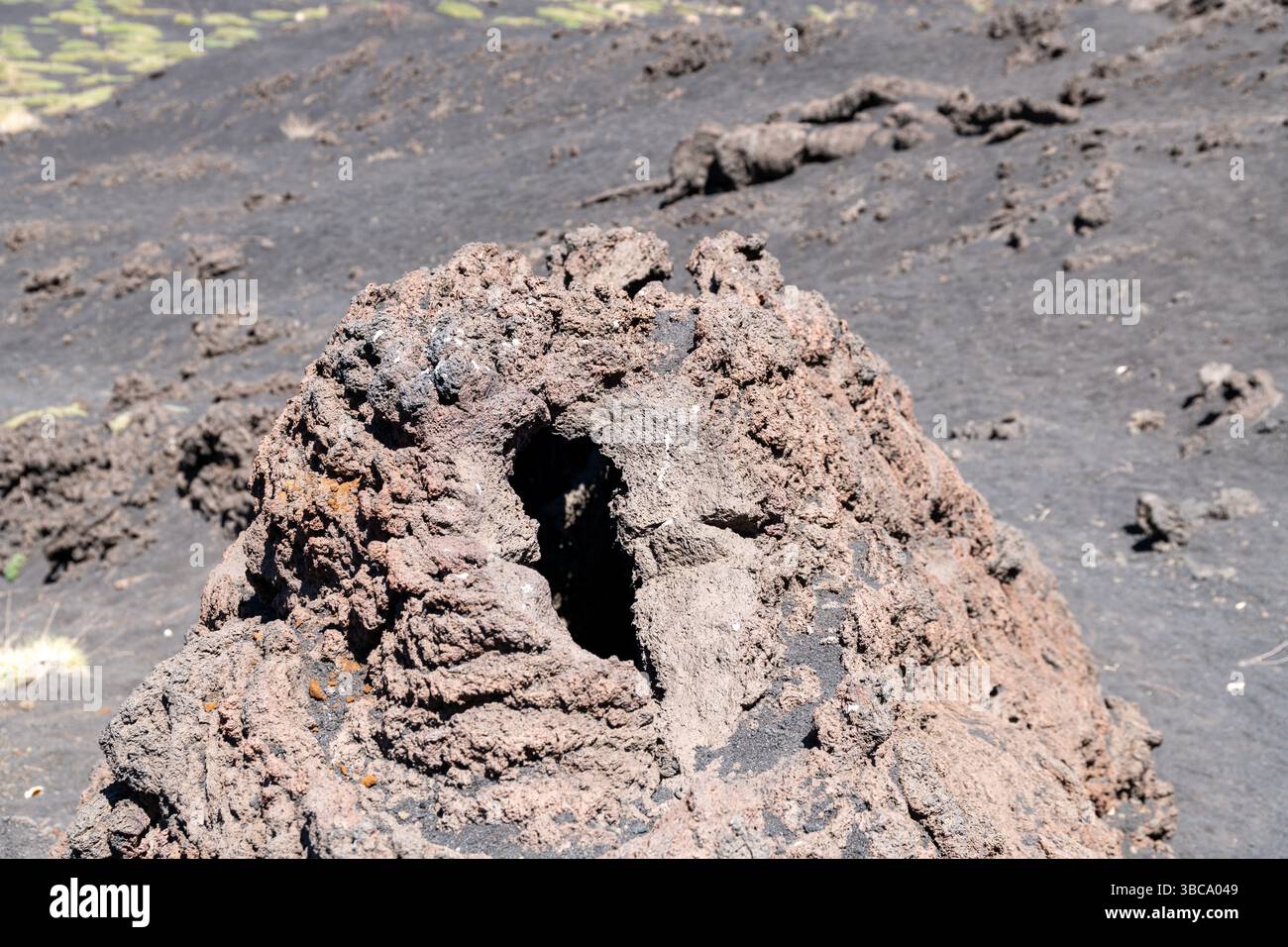 Lava rock with central hole on volcanic surface Stock Photo - Alamy