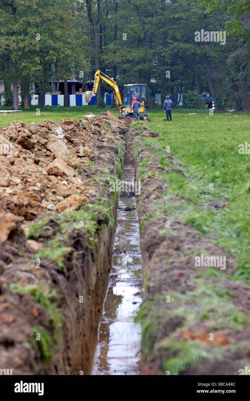 trench for laying cables and pipes. excavator performs excavation work ...