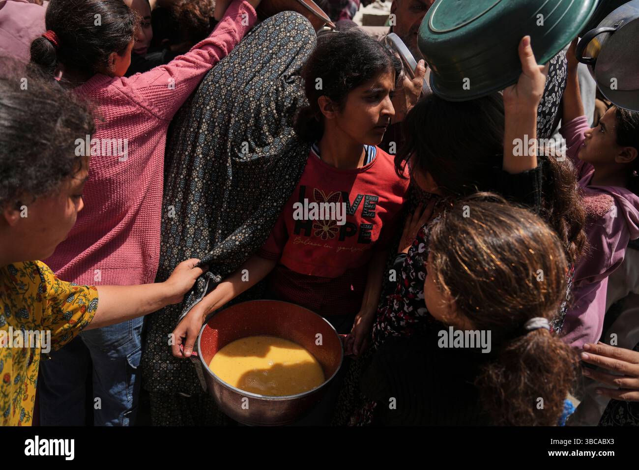 Palestinians struggle to get donated food at a community kitchen in ...