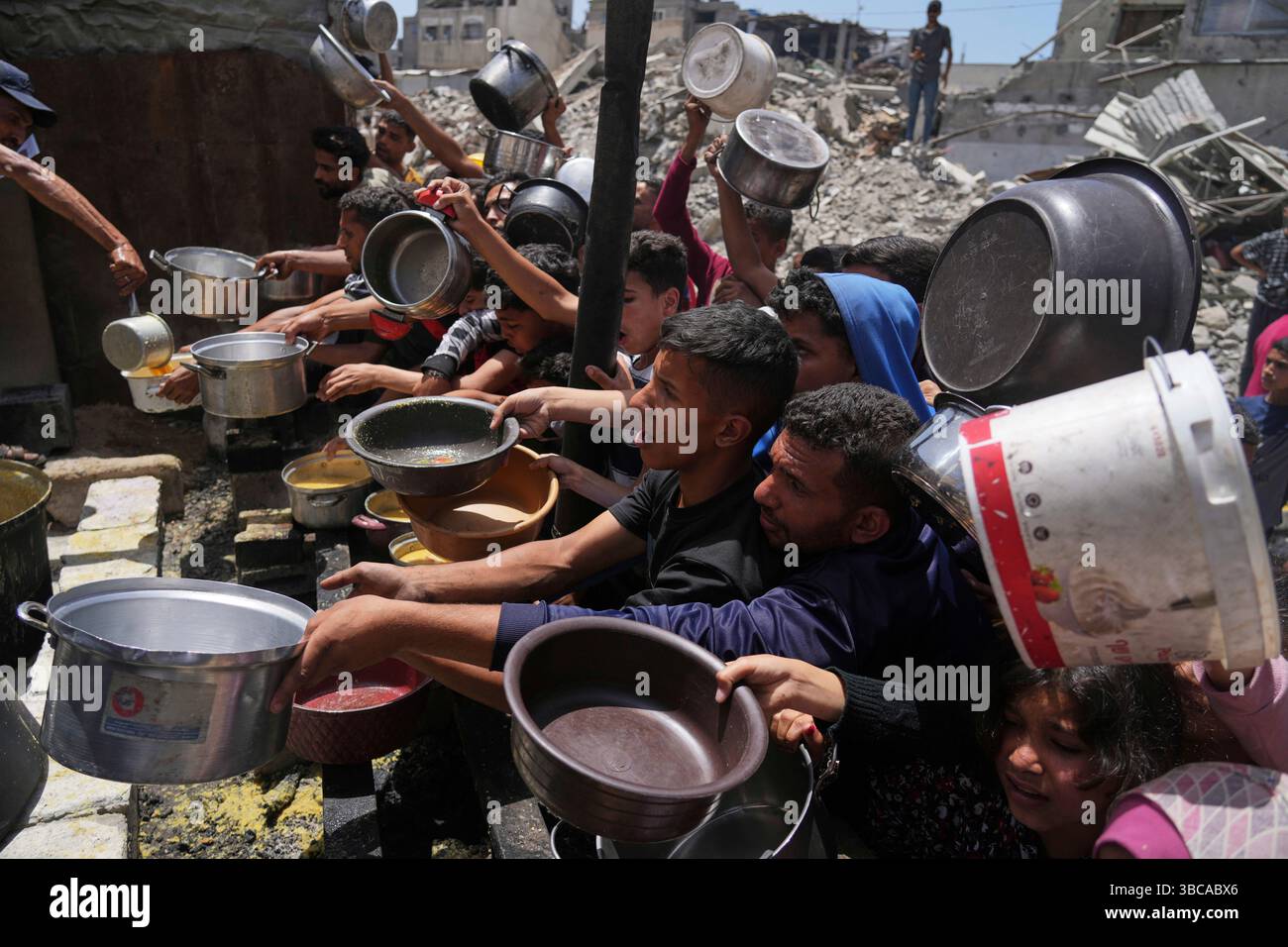 Palestinians struggle to get donated food at a community kitchen in ...