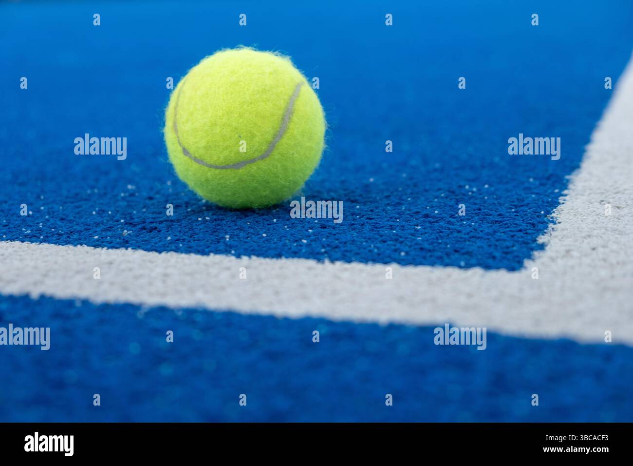 detail of a green ball and white lines on a blue sports surface Stock ...