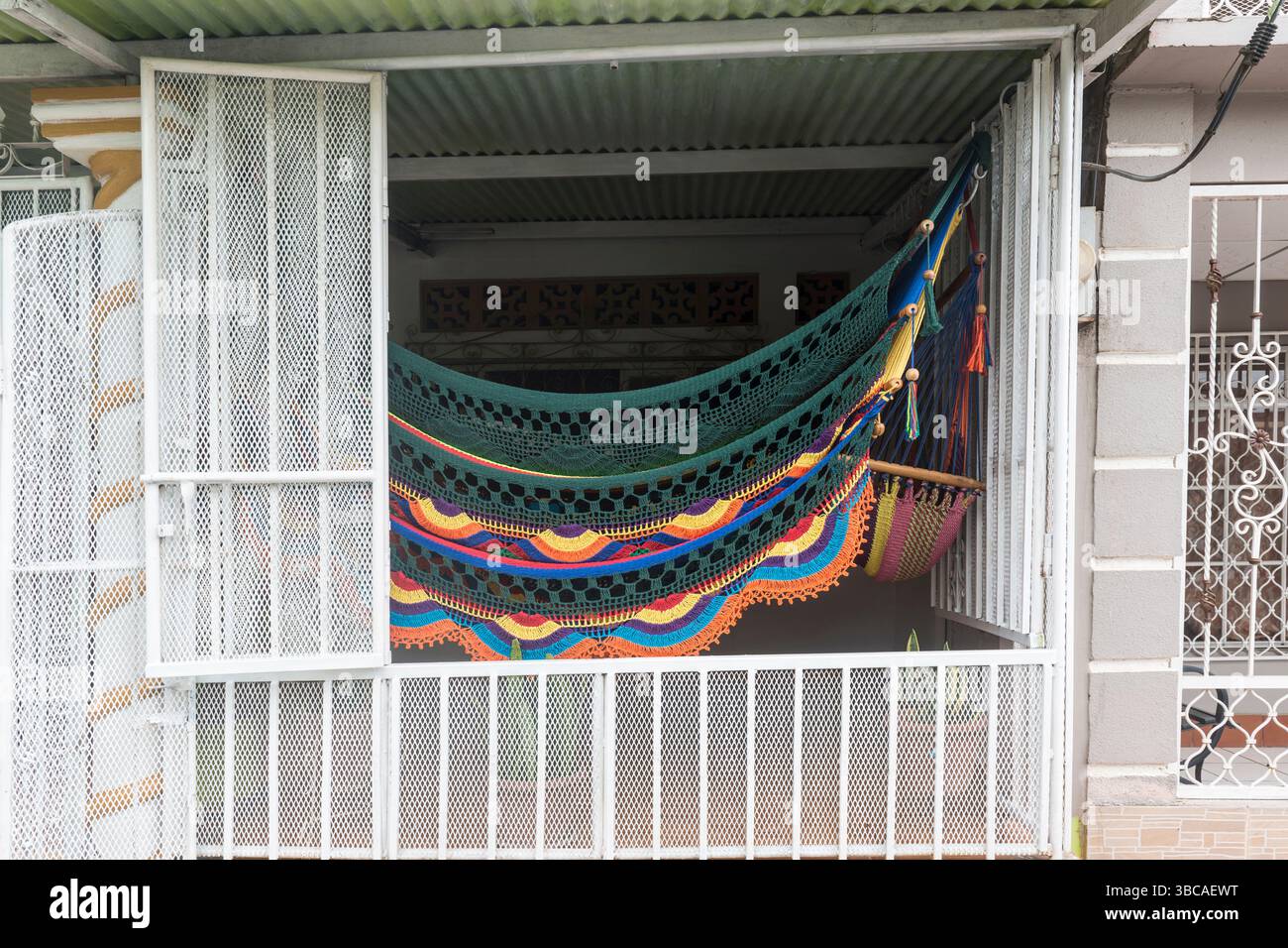 Display of colorful handmade hammocks in a open window of a small ...