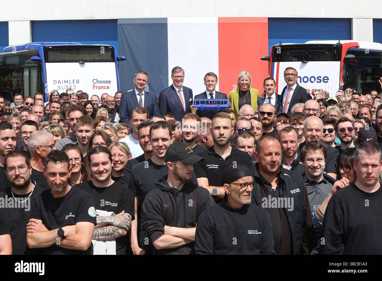 France's President Emmanuel Macron (C), flanked by CEO of Daimler Buses ...