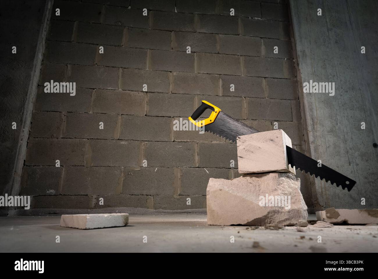 A hand saw for cutting concrete protrudes from a pile of bricks Stock ...