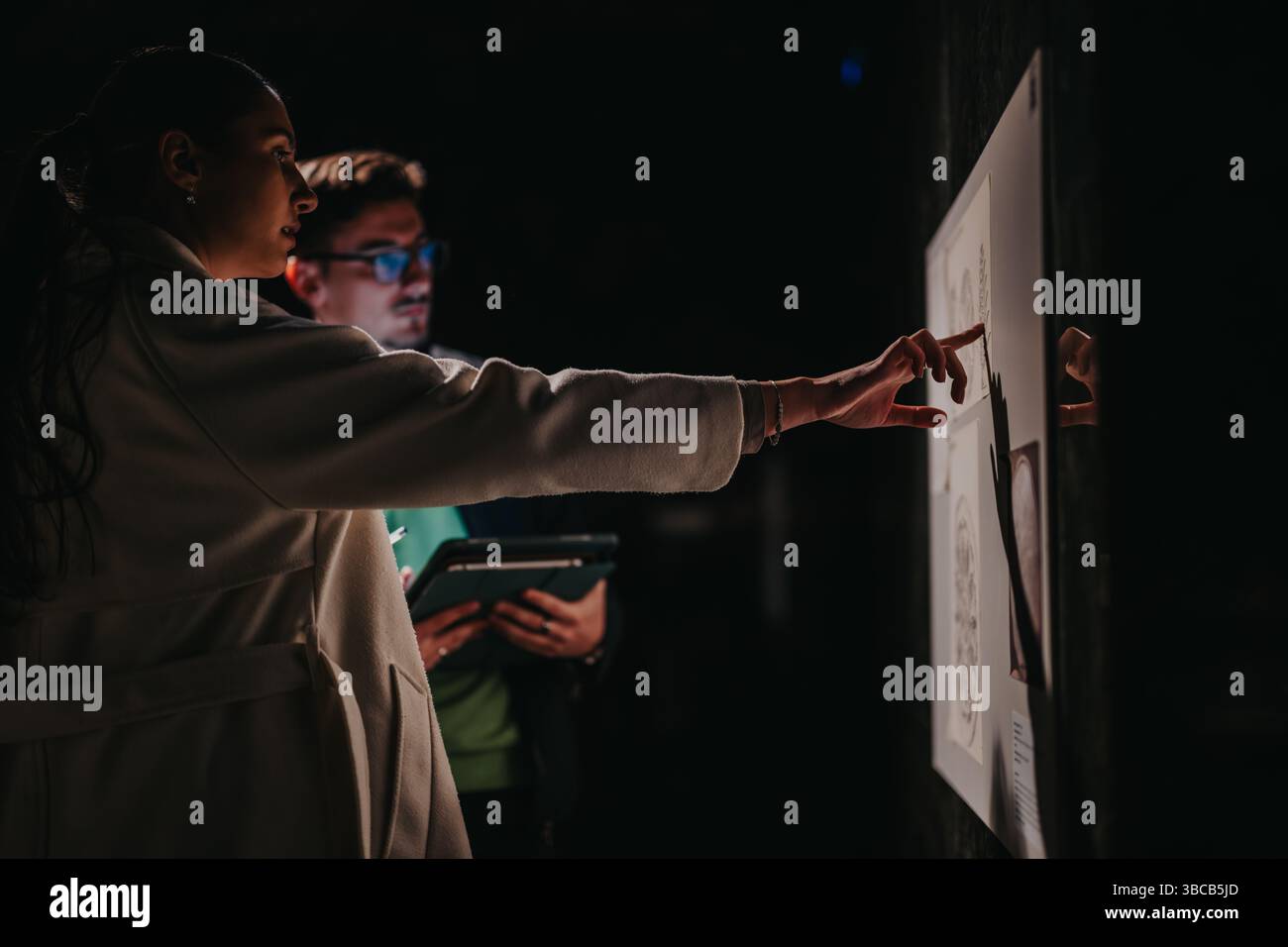 Two people exploring interactive exhibits in a museum setting under ...
