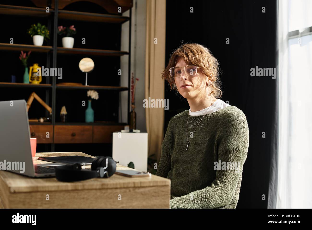 Student studying in a stylish workspace, laptop by side, deep in ...