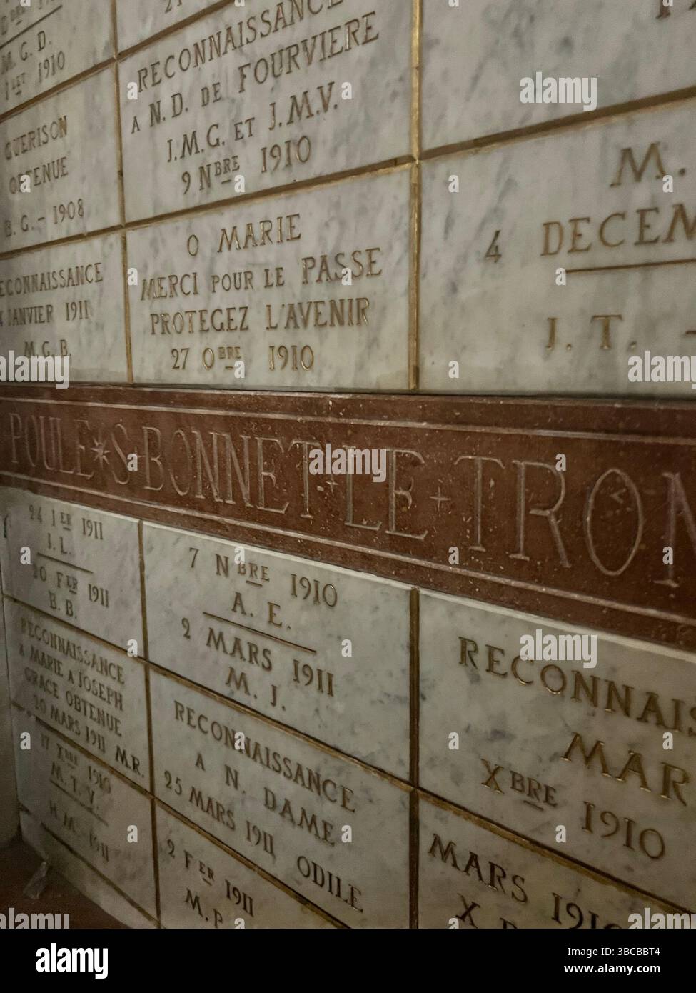 Marble votive plaques line the walls of the Basilica of Notre-Dame de ...
