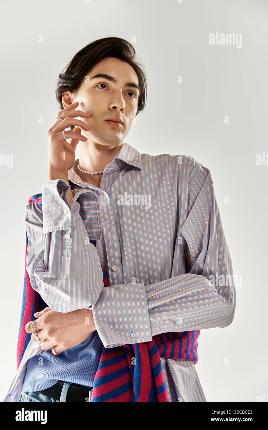 Young non binary individual showcases stylish outfit with an expressive ...